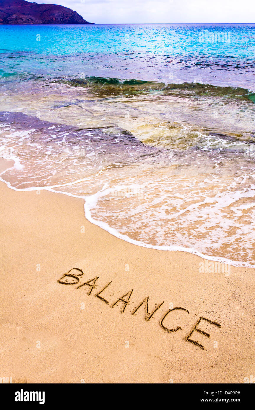 Word BALANCE written on sand, with sea waves in background, peace ...