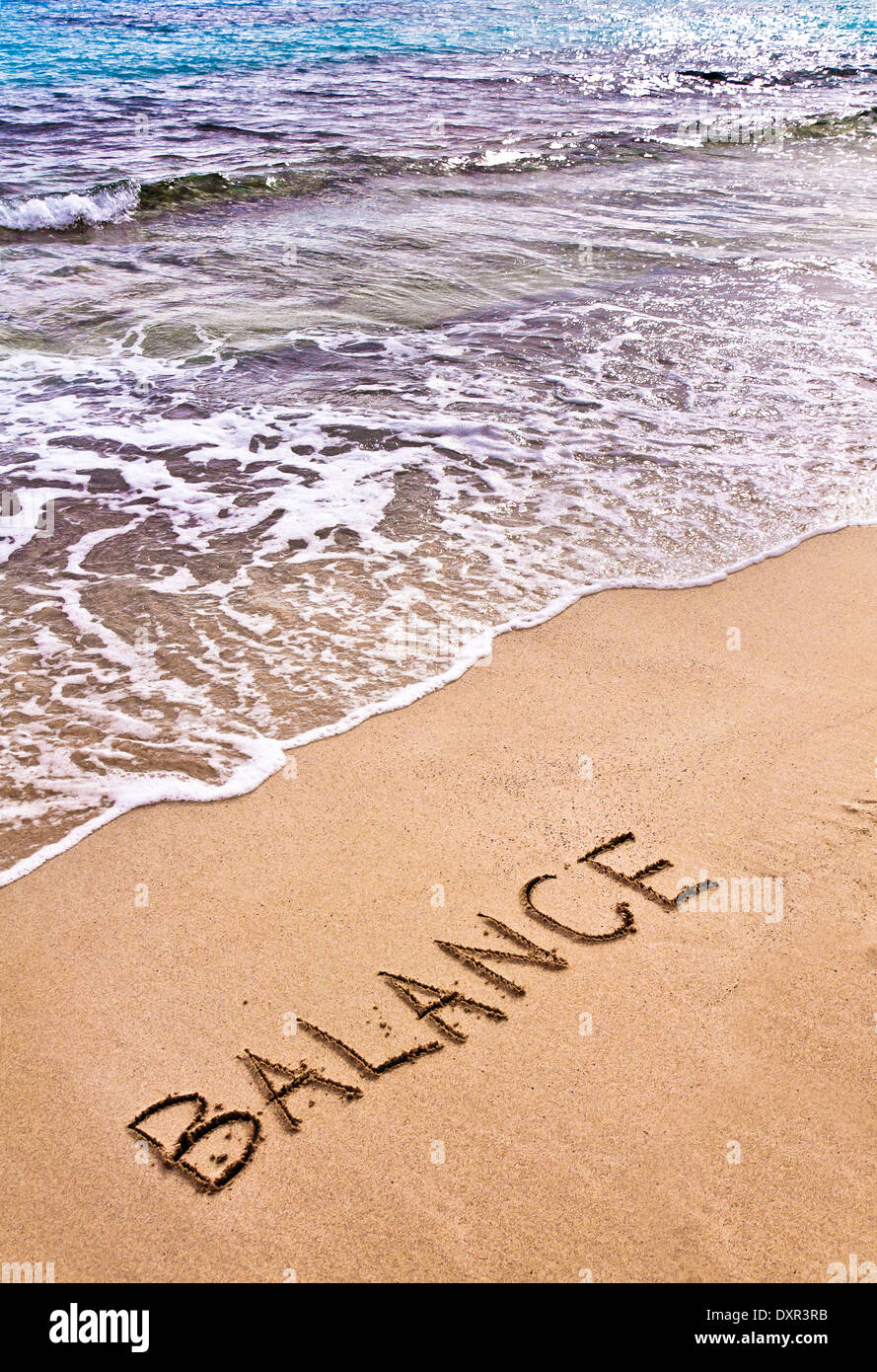 Word BALANCE written on sand, with sea waves in background, peace ...