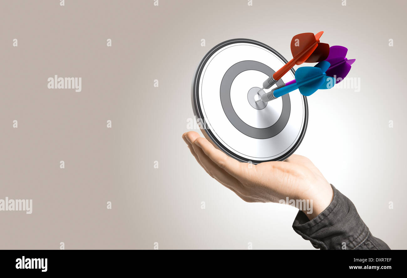 One hand holding a target with three darts hitting the center, beige ...