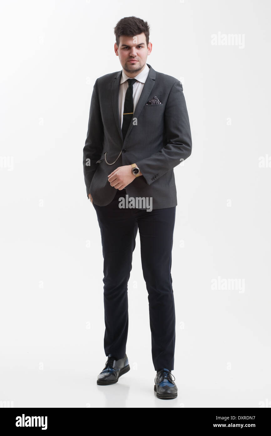 Handsome businessman stands at full height with crossed legs. Full body ...