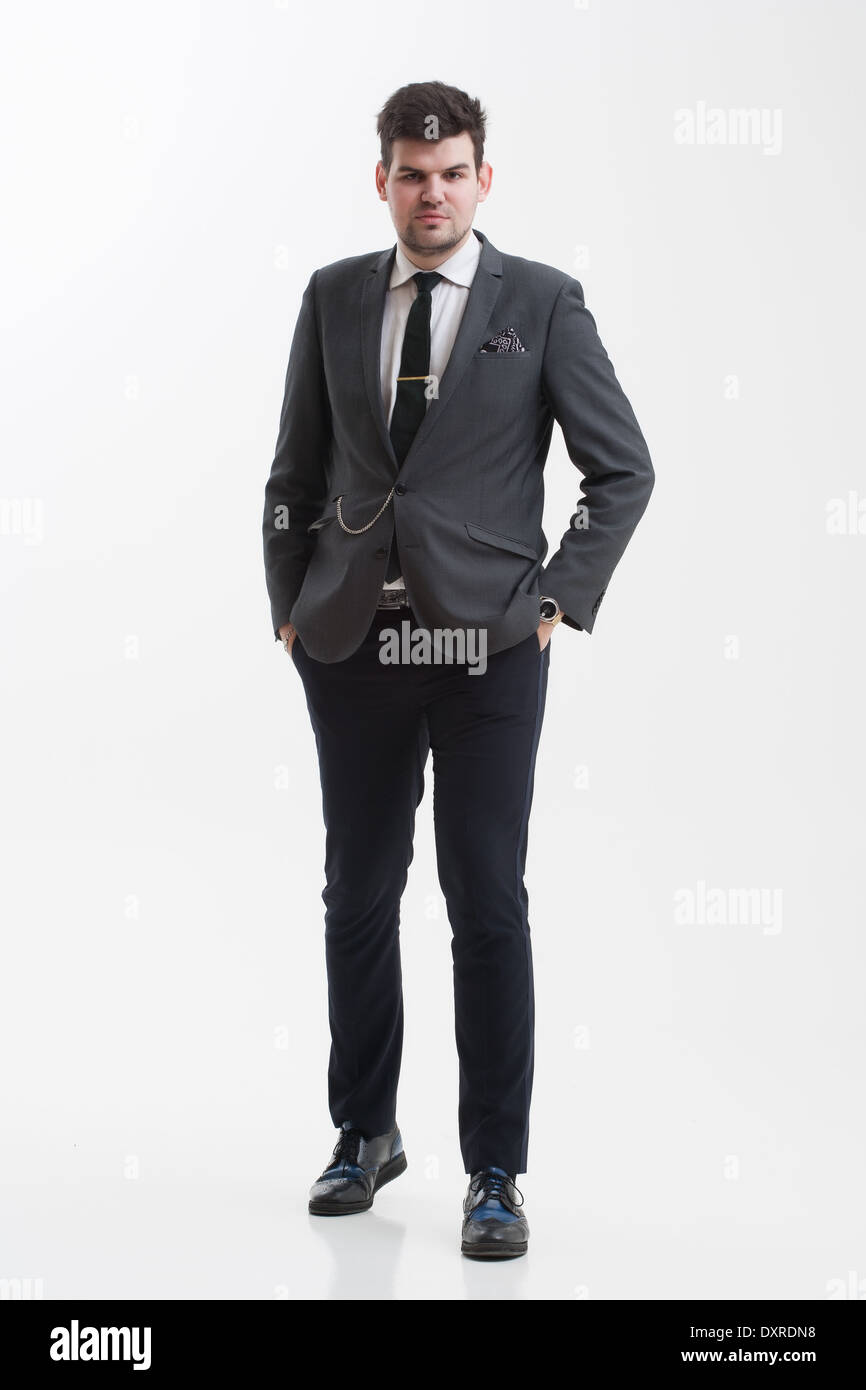 Handsome businessman stands at full height with crossed legs. Full body ...