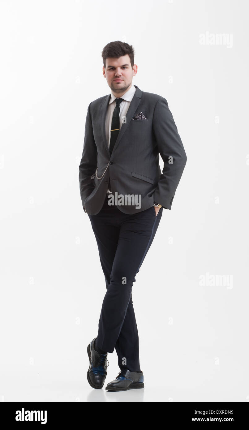 Handsome businessman stands at full height with crossed legs. Full body ...