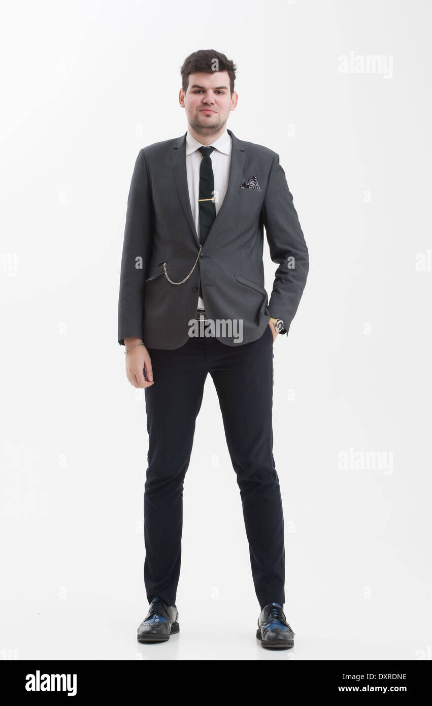 Handsome businessman stands at full height with crossed legs. Full body ...