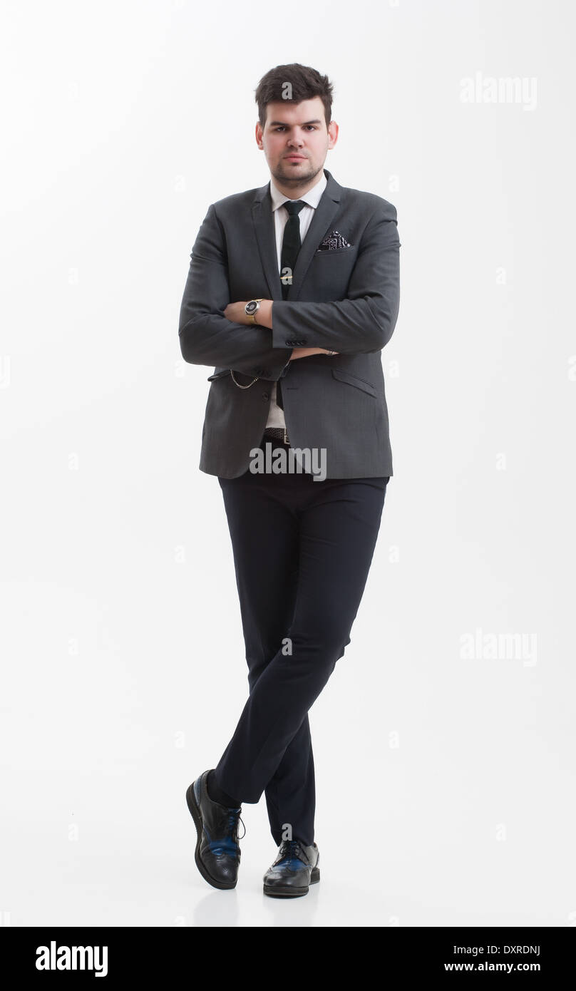 Handsome businessman stands at full height with crossed legs. Full body ...