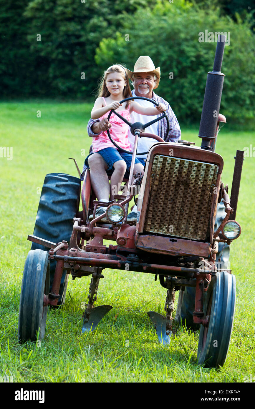 Young girl with grandfather driving a tractor on a farm Stock Photo - Alamy