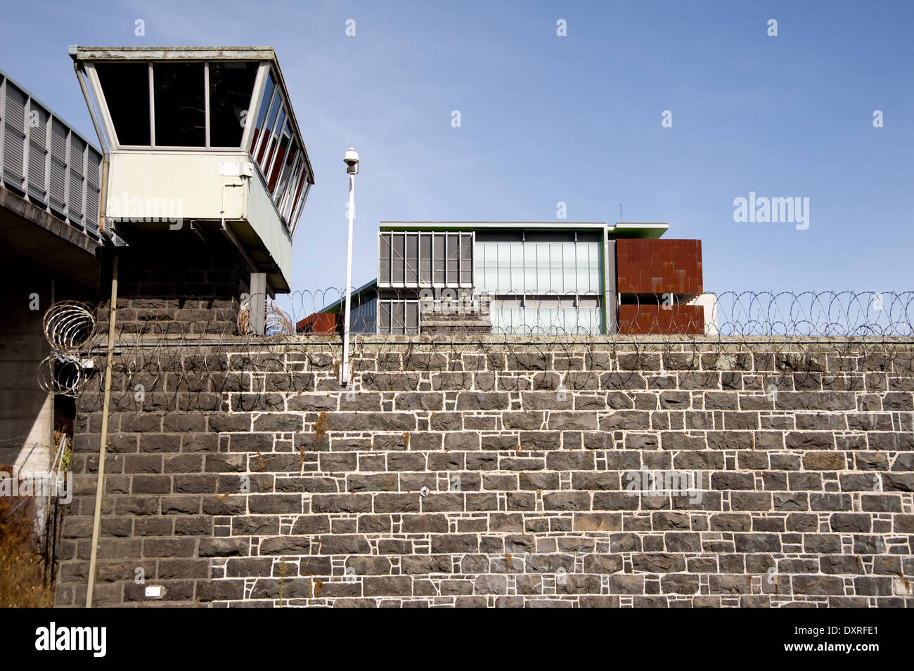Prison walls and watchtower against blue sky. Old stone walls contrast ...
