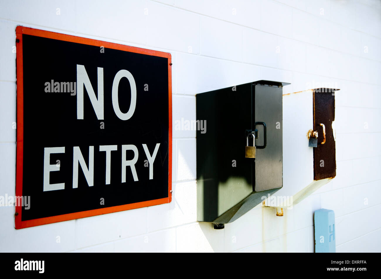 No entry sign and locked boxes on white block wall Stock Photo - Alamy