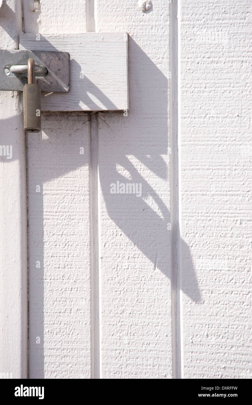 closeup of padlock and shadow on white door Stock Photo - Alamy