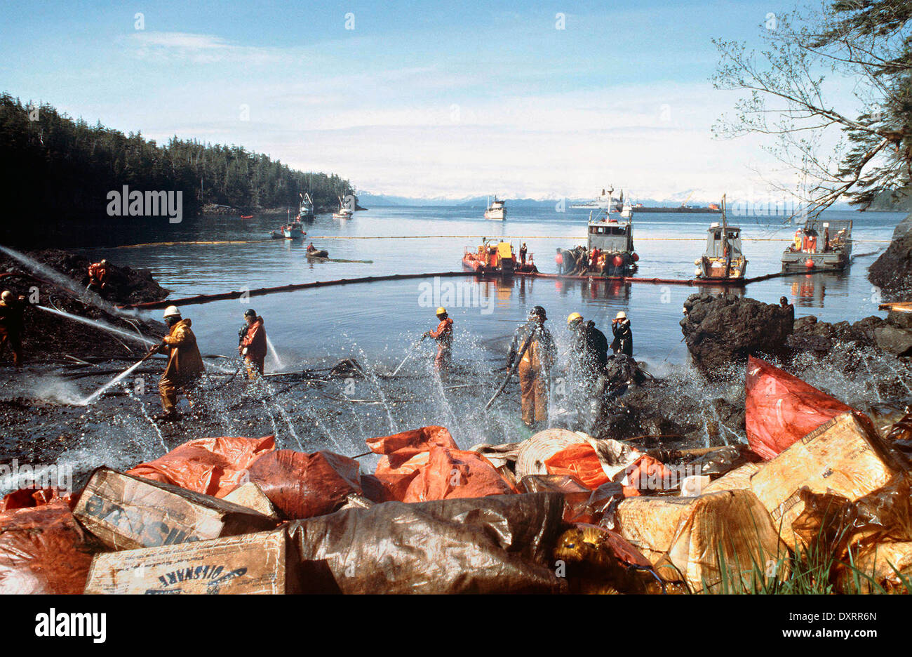 Workers steam blast rocks and wash down the shoreline soaked in crude ...
