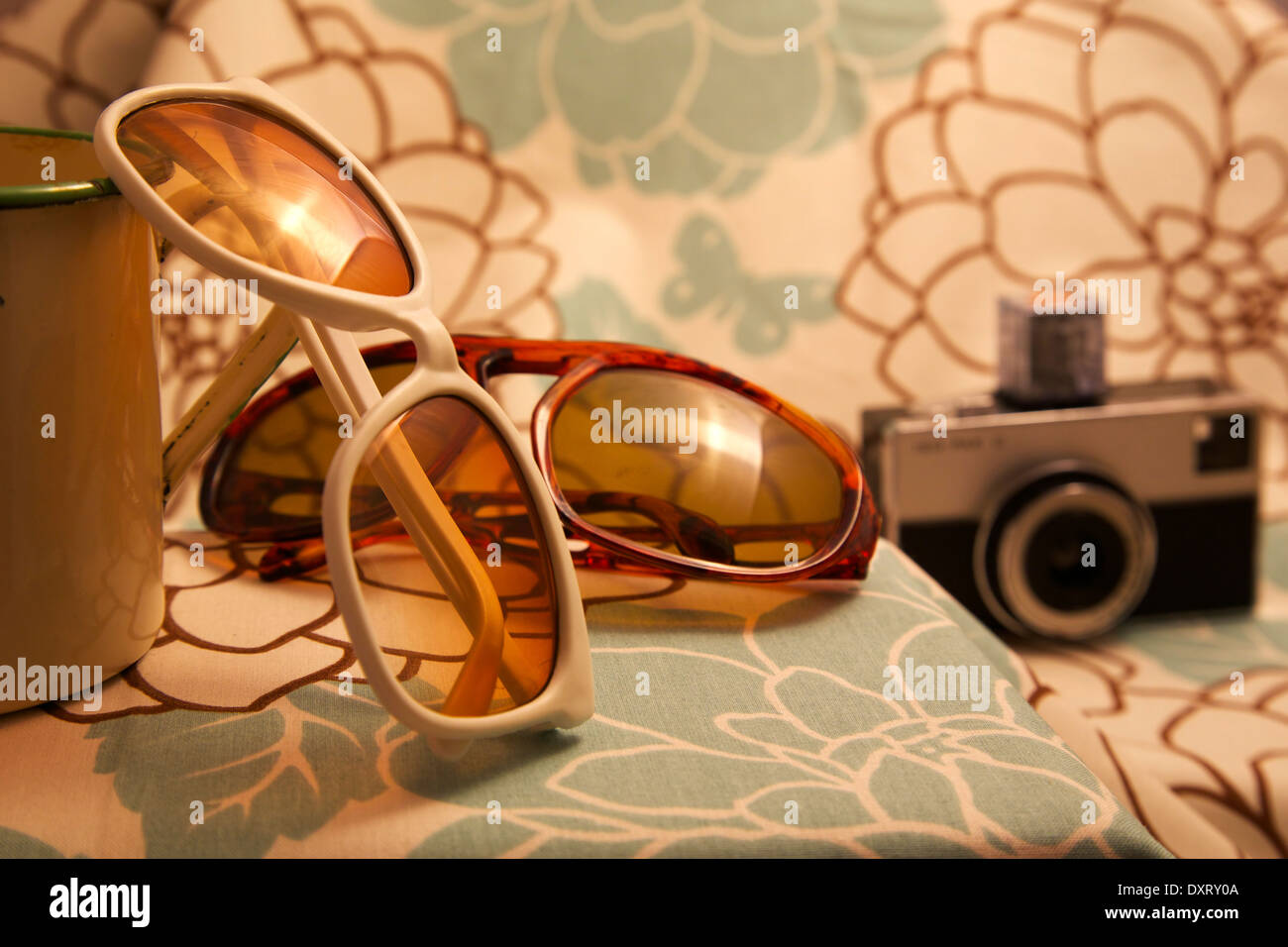 Retro still life with camera, enamel mug and sunglasses Stock Photo - Alamy