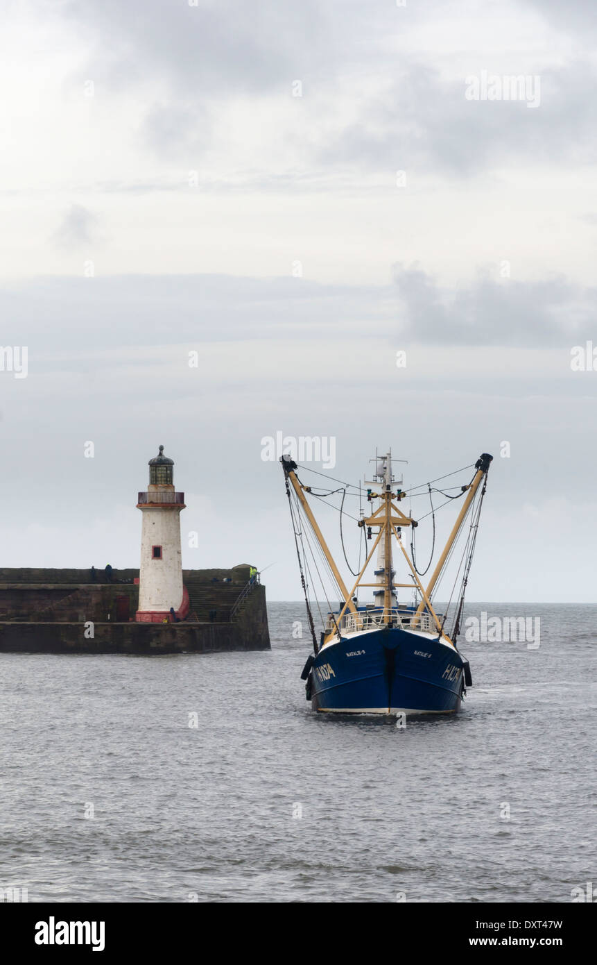 A blue trawler entering Whitehaven harbour , returning from a fishing ...