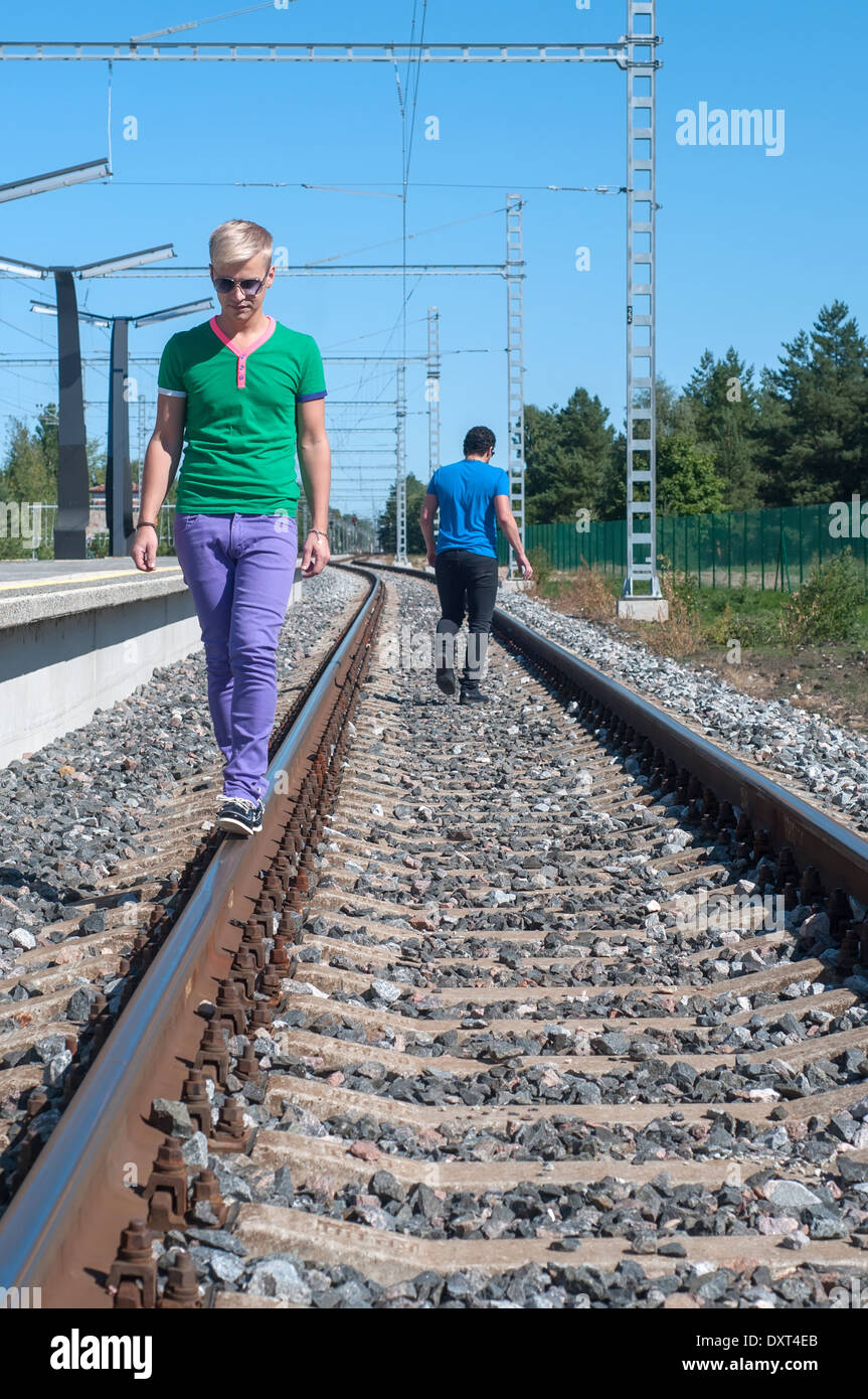 Handsome man walking on train tracks Stock Photo - Alamy