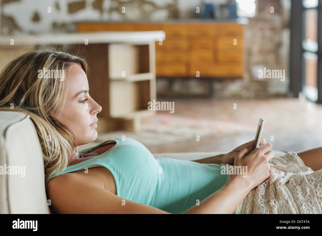 Woman laying on sofa and texting with cell phone Stock Photo - Alamy