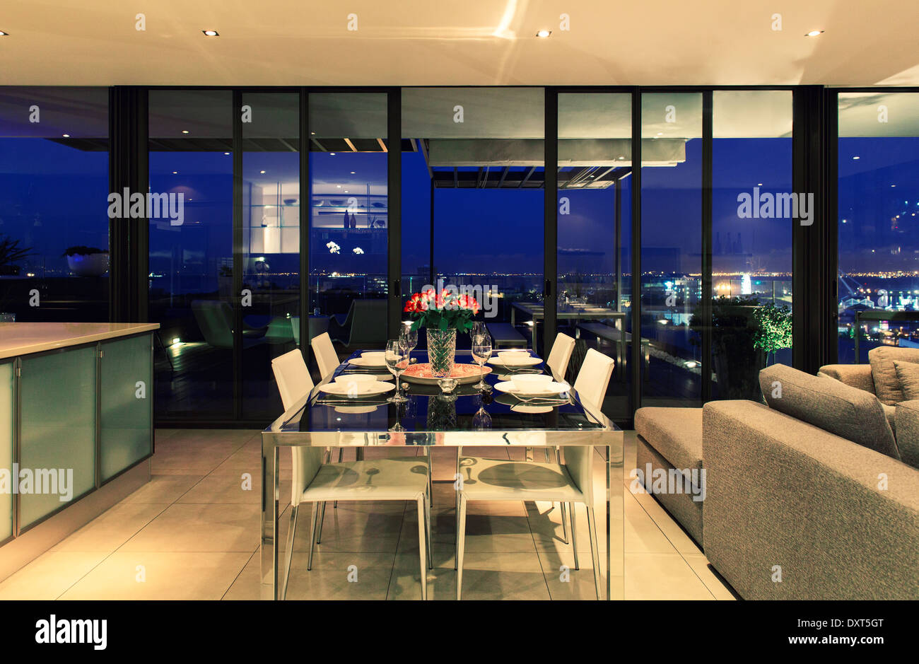 Illuminated modern dining room overlooking city Stock Photo - Alamy