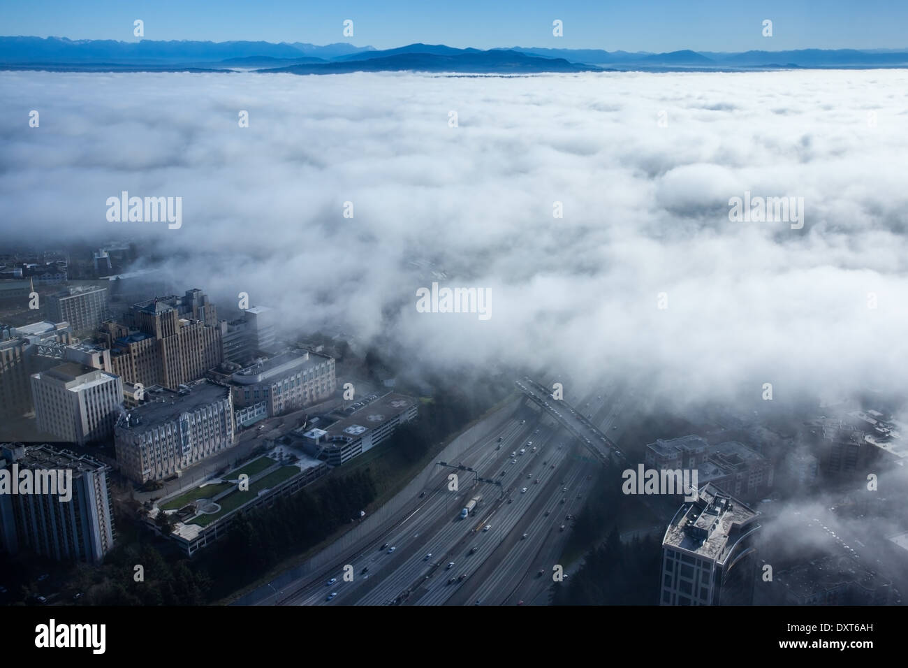 Bird's eye view of fog rolling in over Freeway in the city of Seattle ...