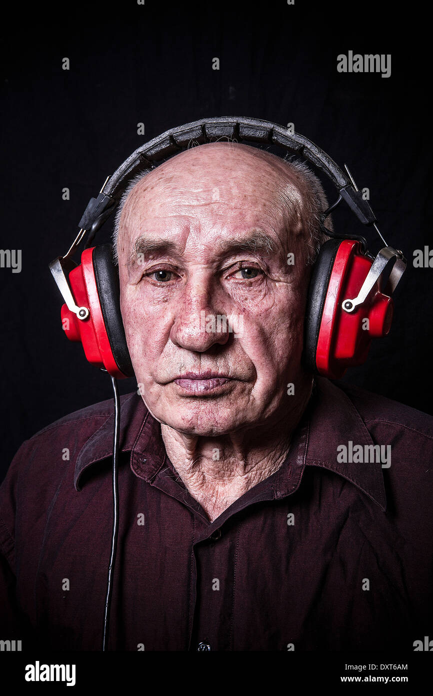 Studio portrait of an old man in headphones Stock Photo - Alamy