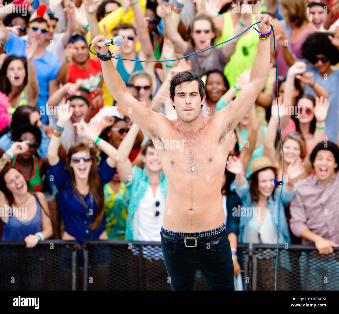 Fans cheering behind performer on stage at music festival Stock Photo ...