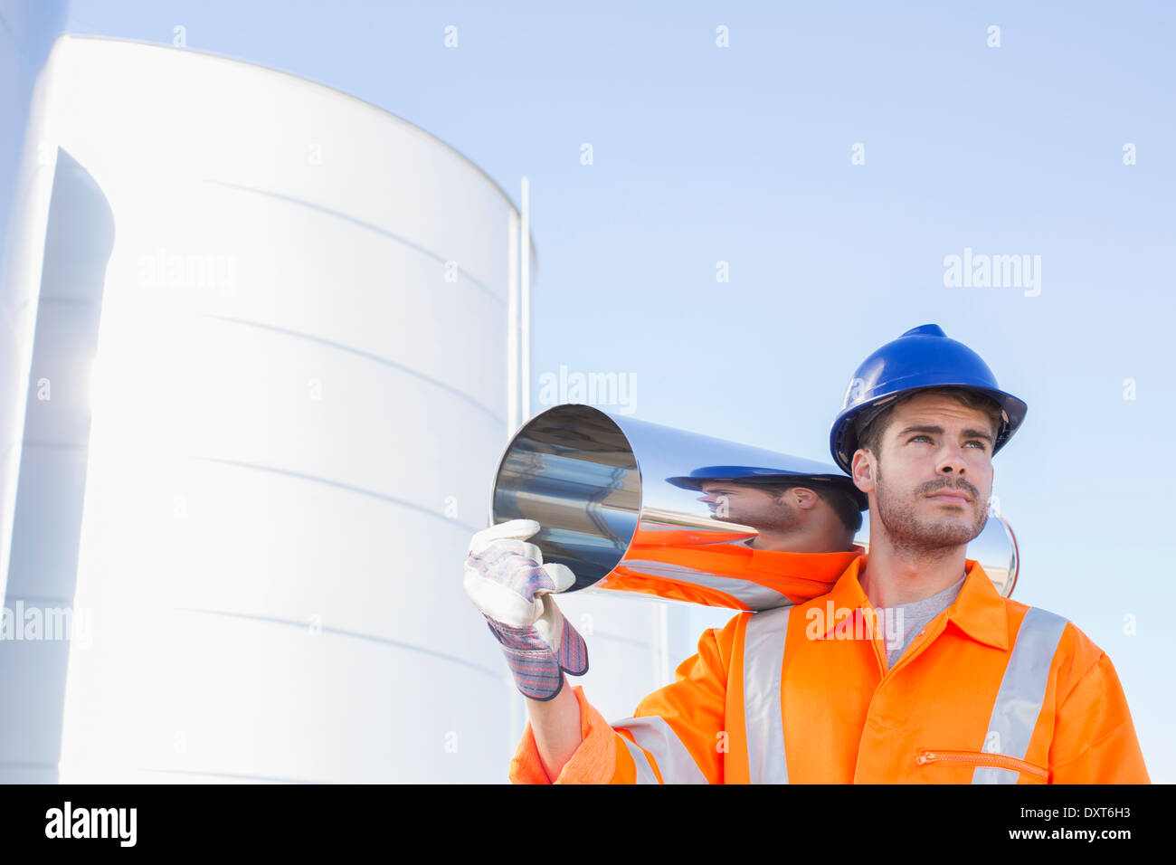 Worker carrying stainless steel tube near silage storage tower Stock ...