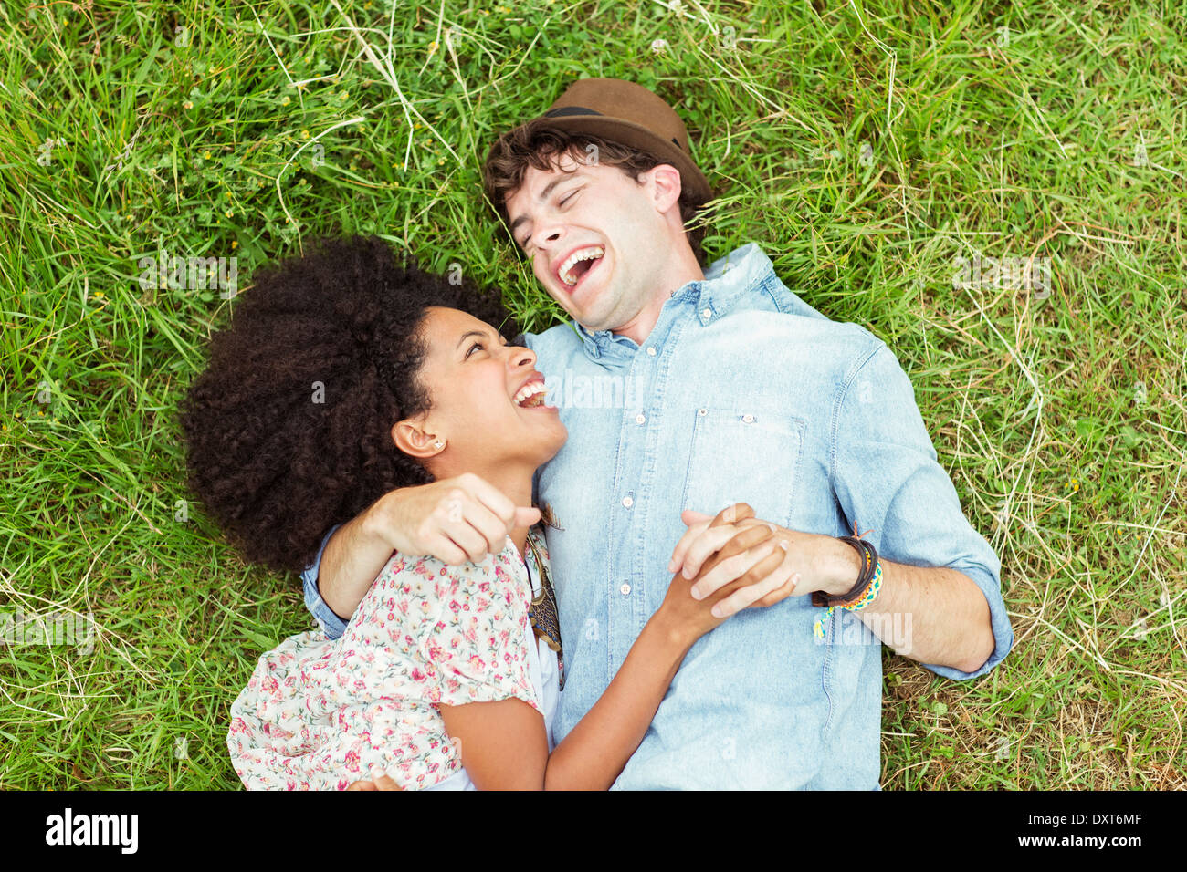 Laughing couple laying in grass Stock Photo - Alamy
