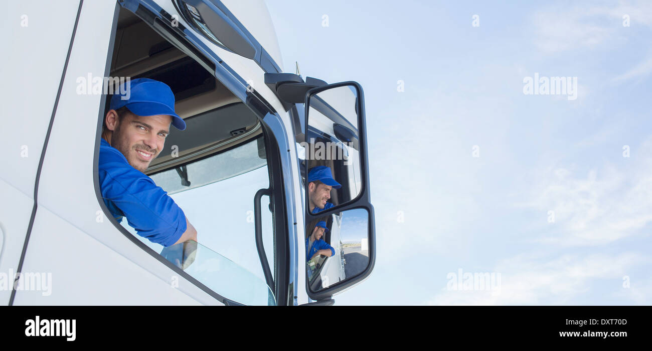 Portrait of smiling truck driver leaning out window Stock Photo - Alamy