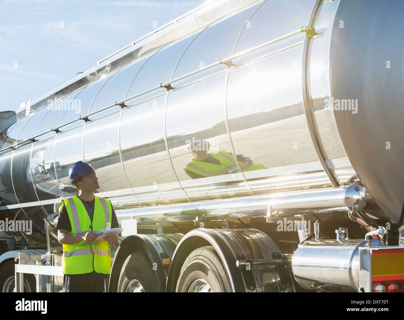 Worker with clipboard checking stainless steel milk tanker Stock Photo ...