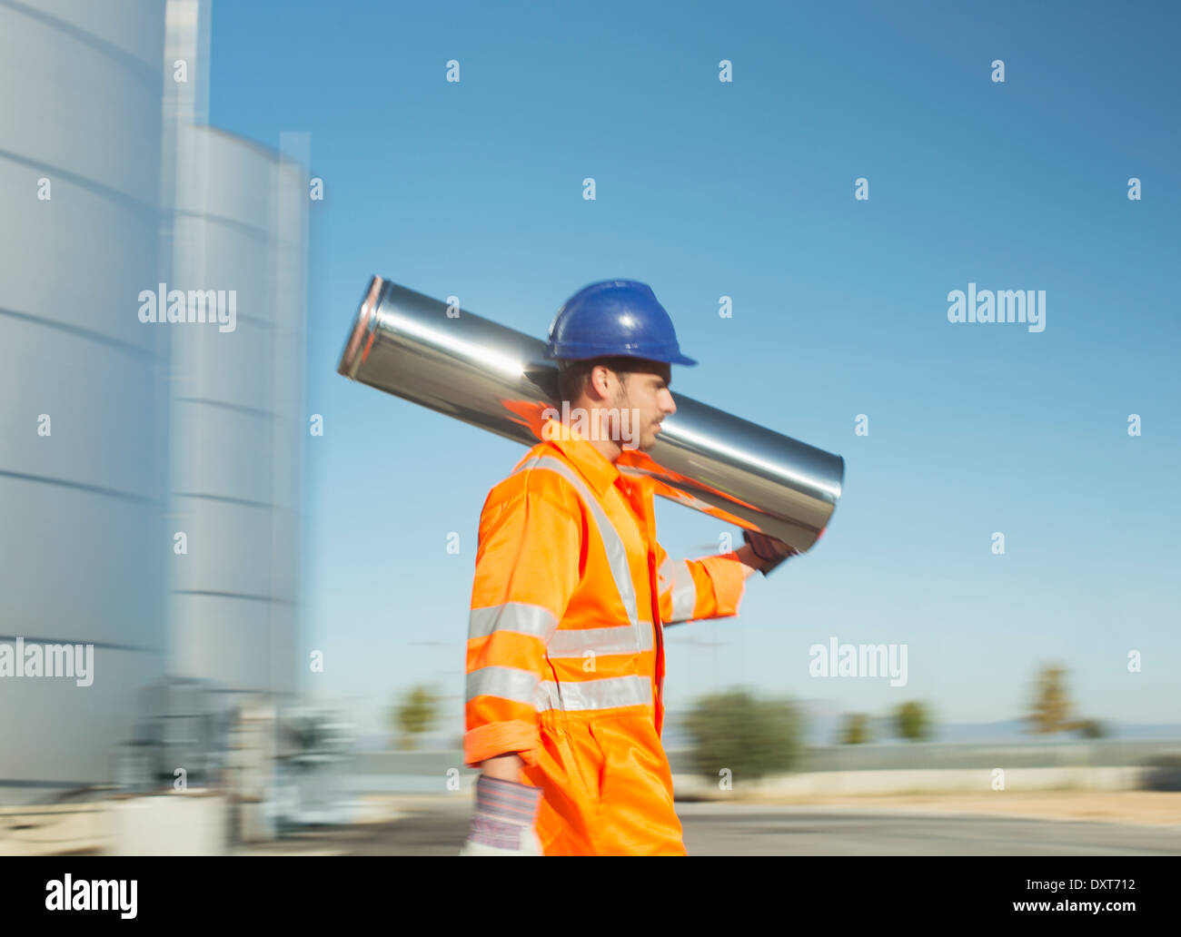 Worker carrying stainless steel tube Stock Photo - Alamy
