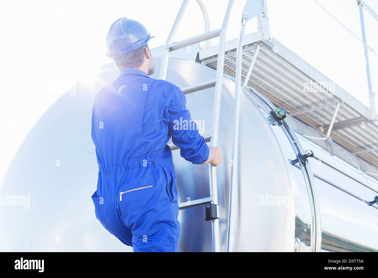 Worker climbing ladder at back of stainless steel milk tanker Stock ...