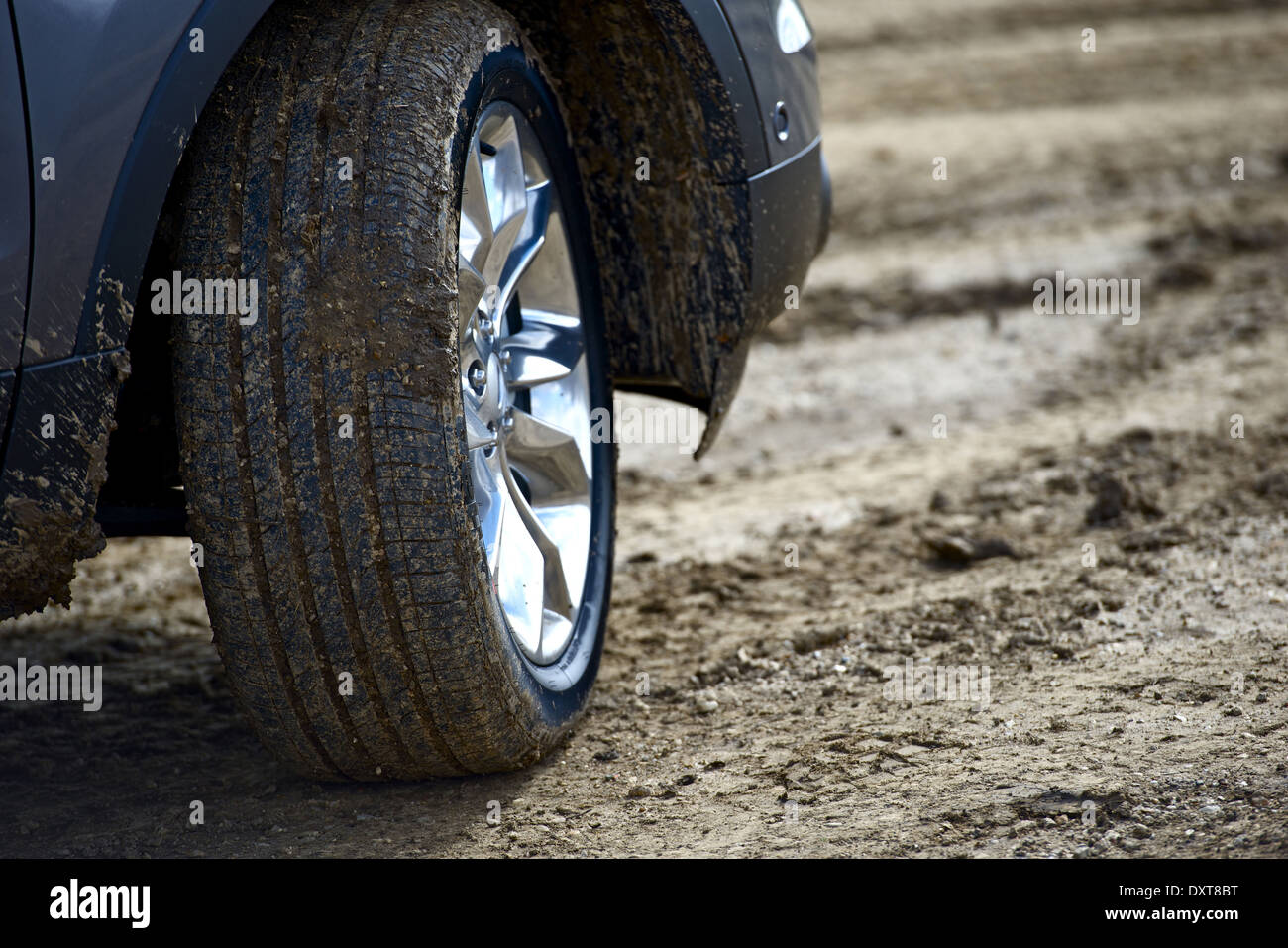 On the Dirty Road. Brand New SUV Wheel on the Muddy Road. Wheel Closeup ...
