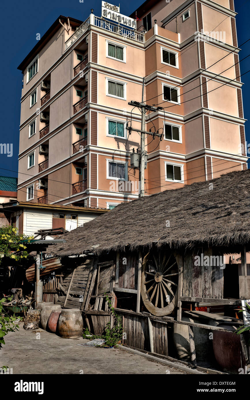 Old thatched shack home dwarfed by newly constructed high rise ...