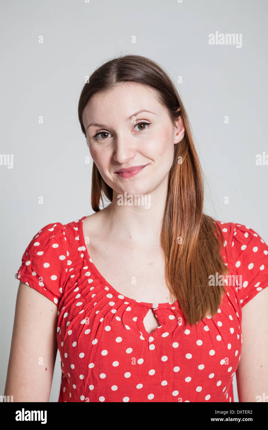 Studio portrait of happy smiling attractive woman wearing spotty red ...