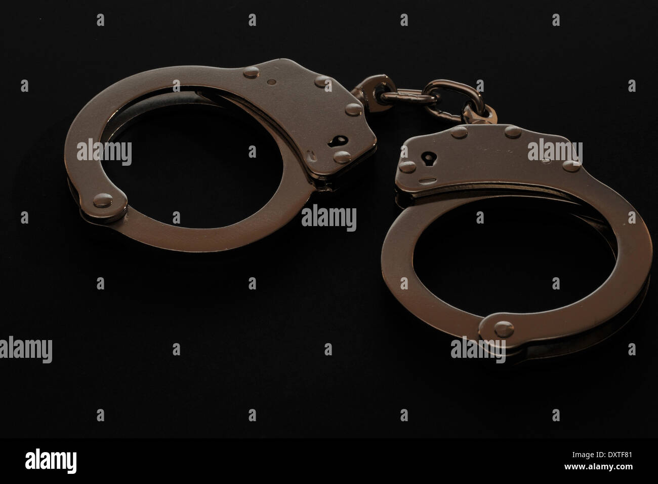Handcuffs on black background Stock Photo - Alamy