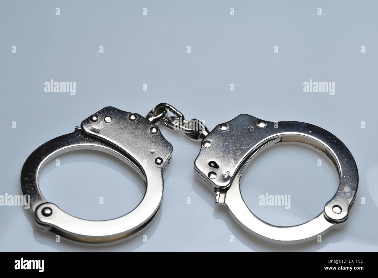 Handcuffs on light background Stock Photo - Alamy