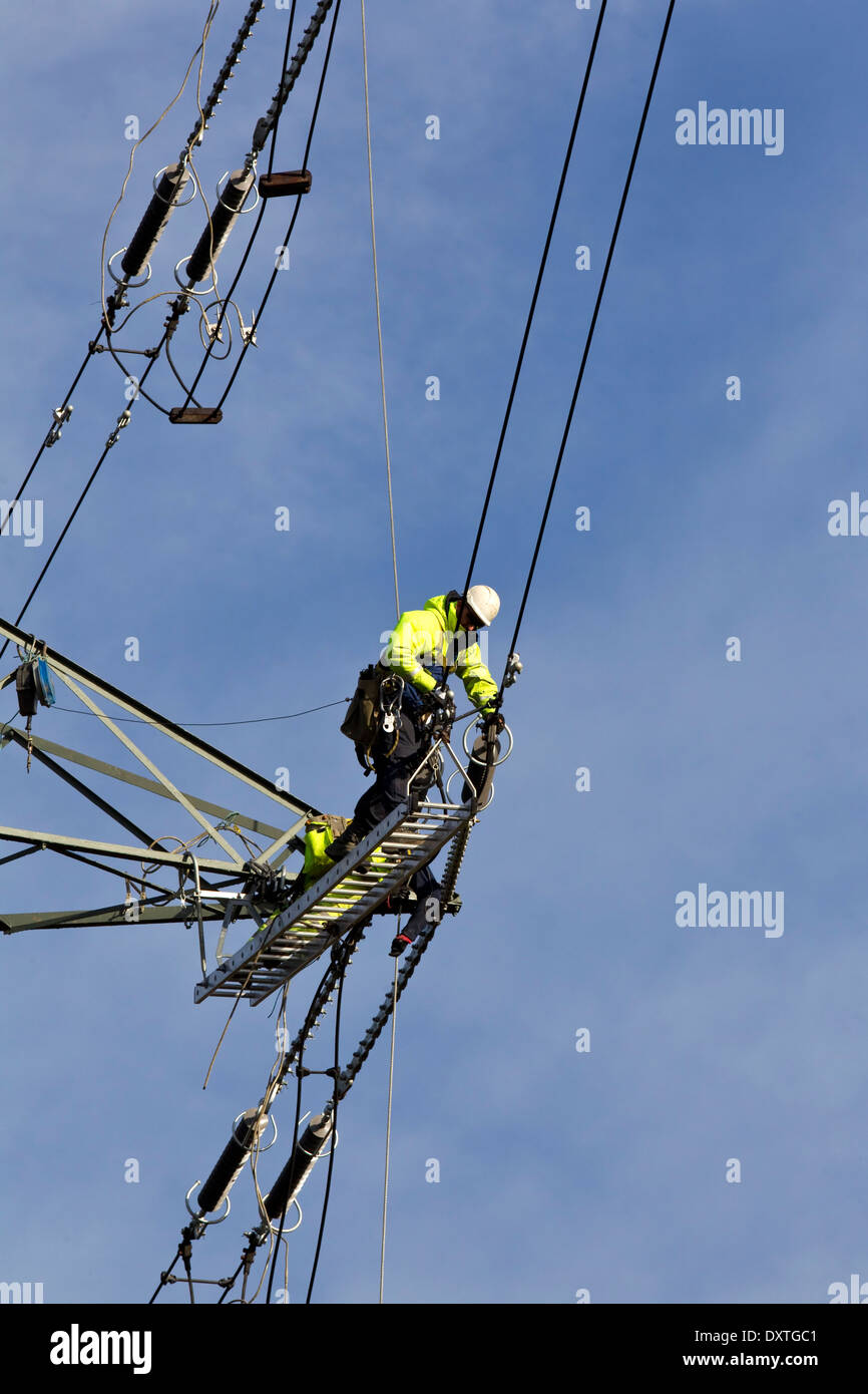 Electrical engineers working overhead on high tension power line ...