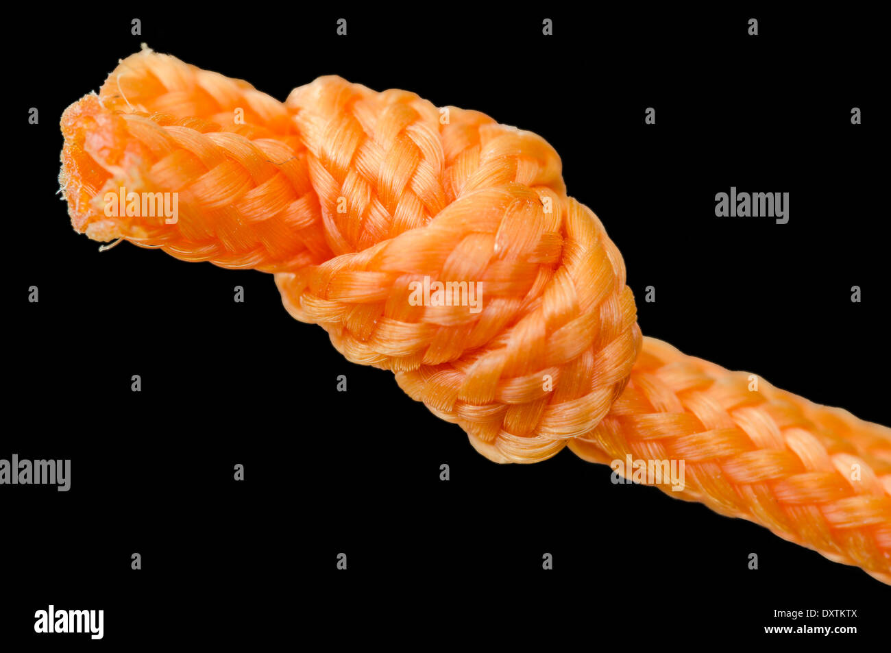 Knot. Closeup image of thick orange string tied in a knot, with a black ...