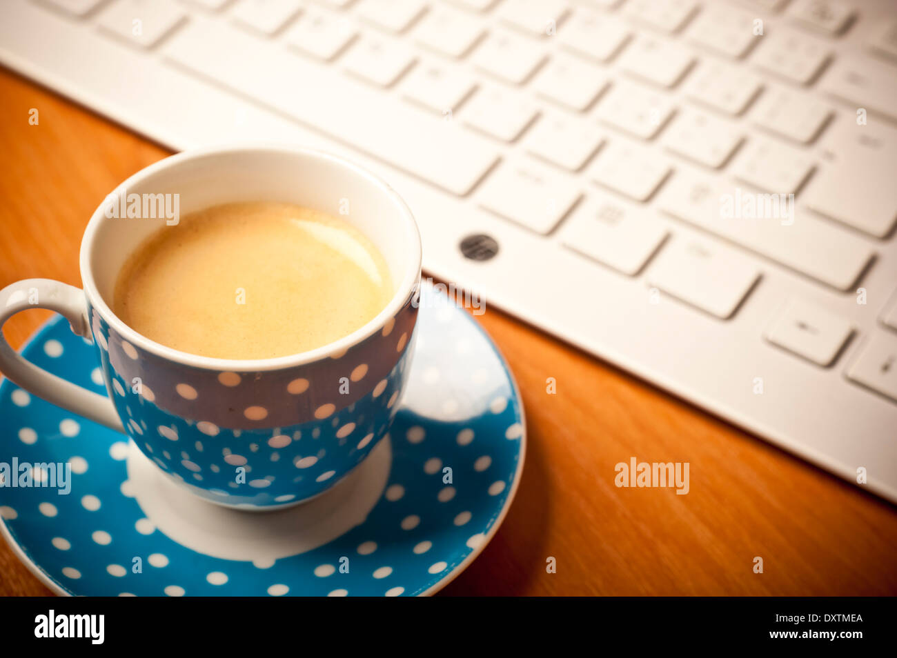 coffee cup and computer keyboard on desk Stock Photo - Alamy