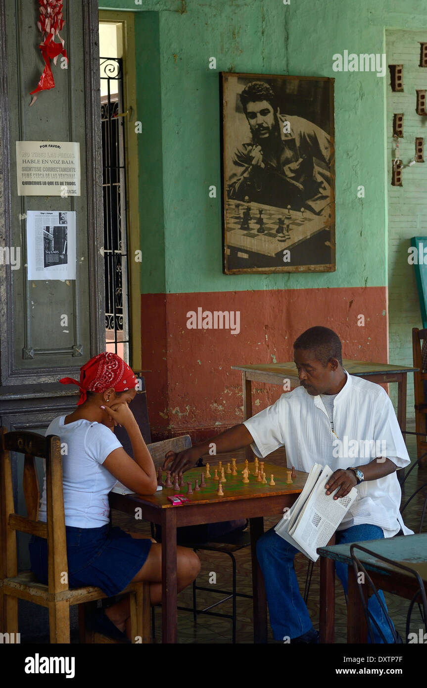Locals playing chess at a chess club, with a poster of Che Guevara in ...