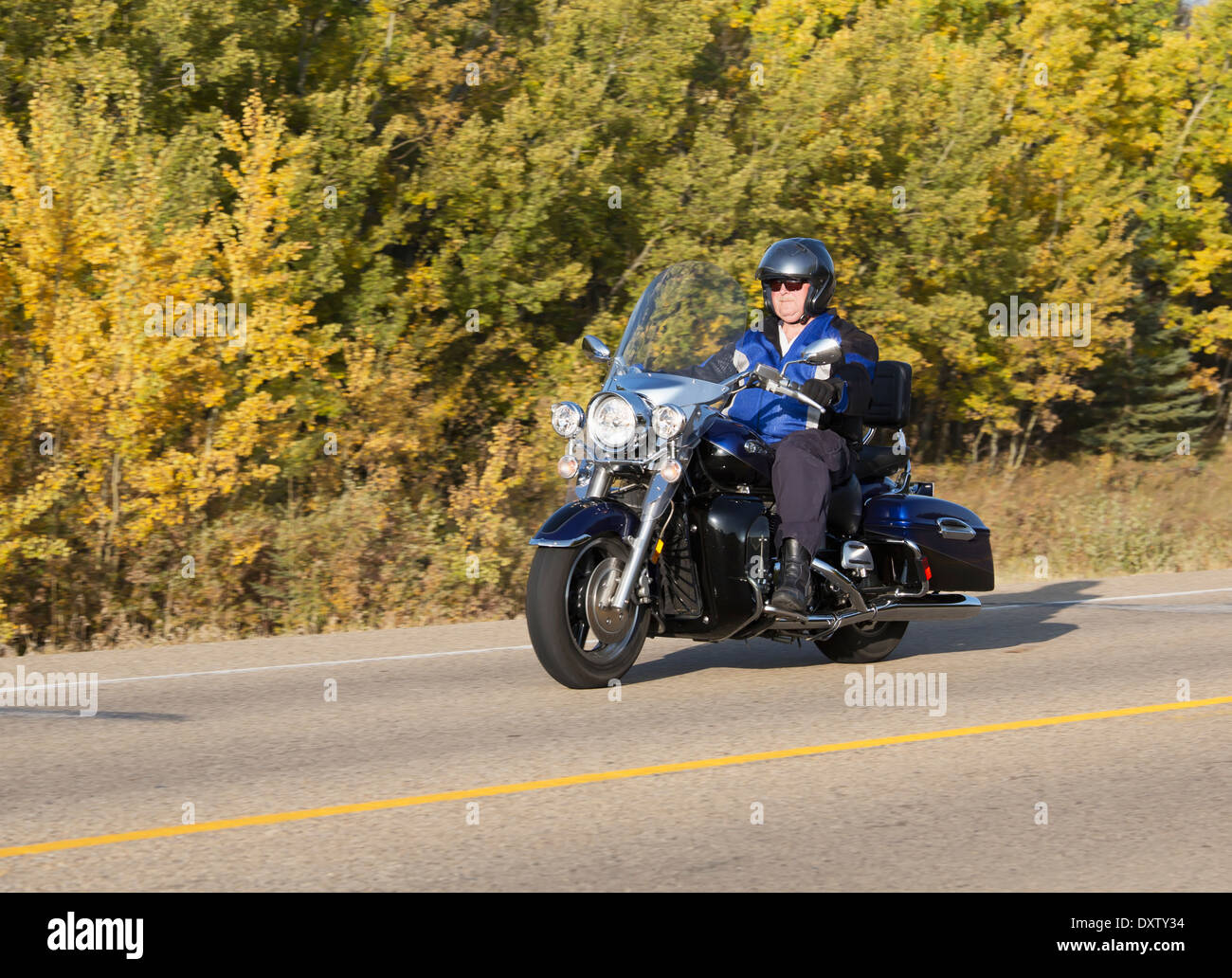 Mature man riding a motorcycle on highway; Edmonton, Alberta, Canada ...