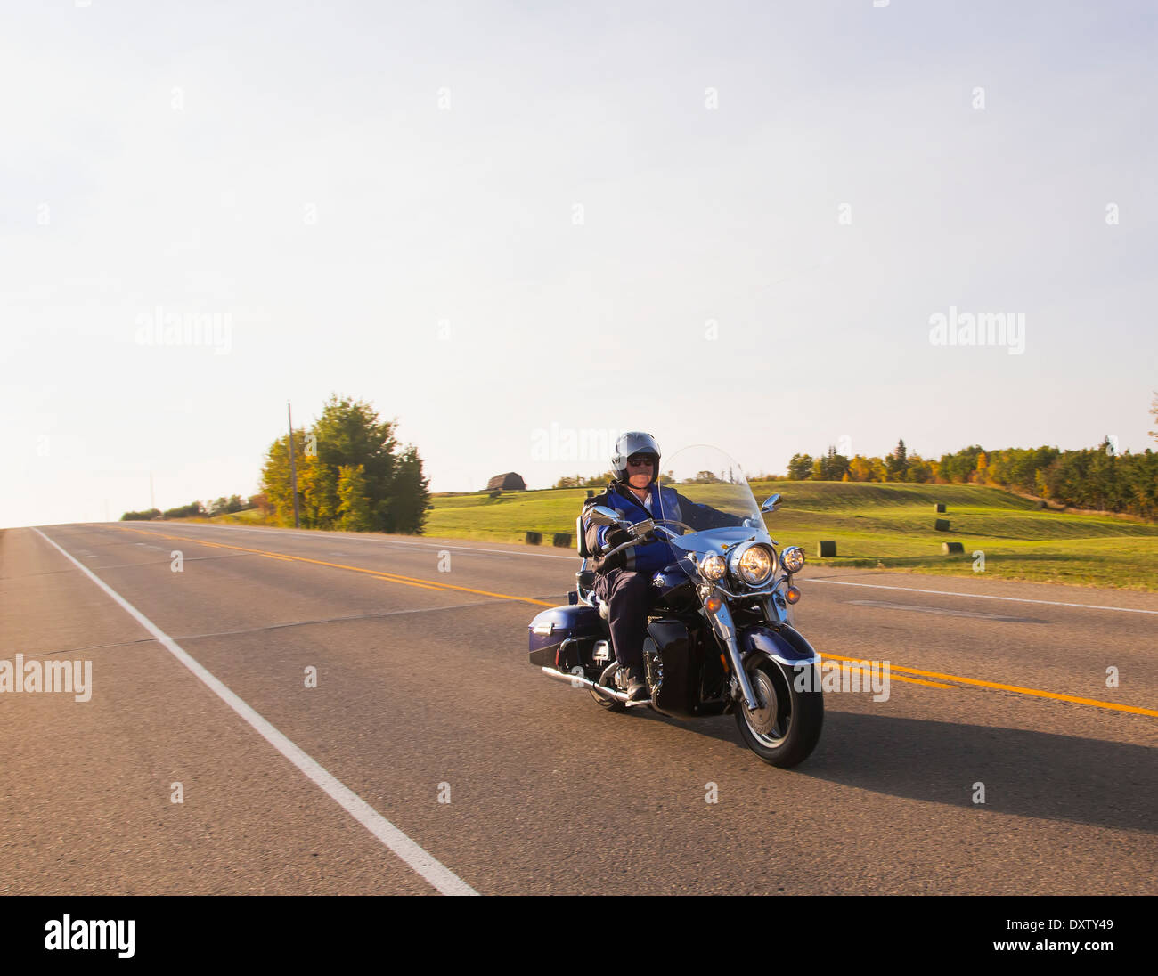 Mature man riding a motorcycle on highway; Edmonton, Alberta, Canada ...