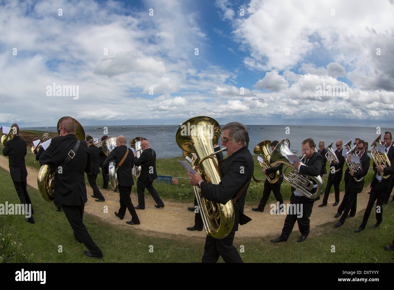 Musicians playing brass instruments marching at the water's edge; South ...