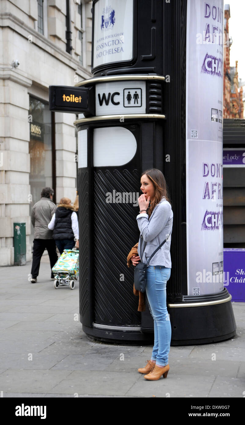 Young woman waiting outside public toilets cubicle in Sloane Square ...