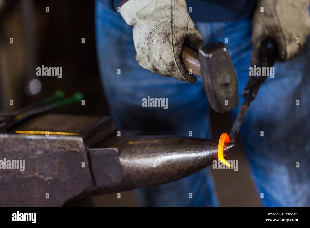 blacksmith bending hot iron on the anvil Stock Photo - Alamy