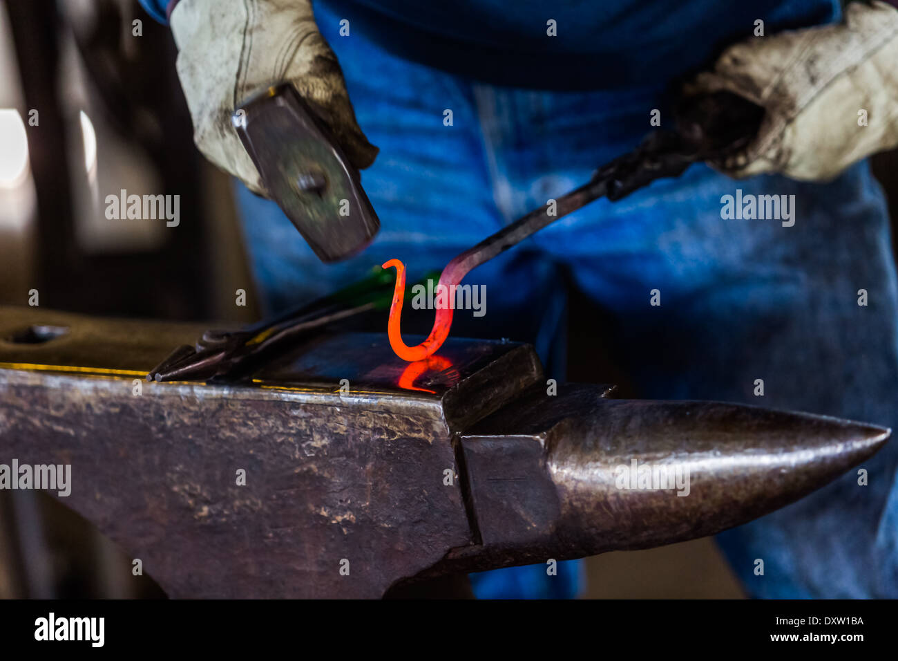 blacksmith bending hot iron on the anvil Stock Photo - Alamy