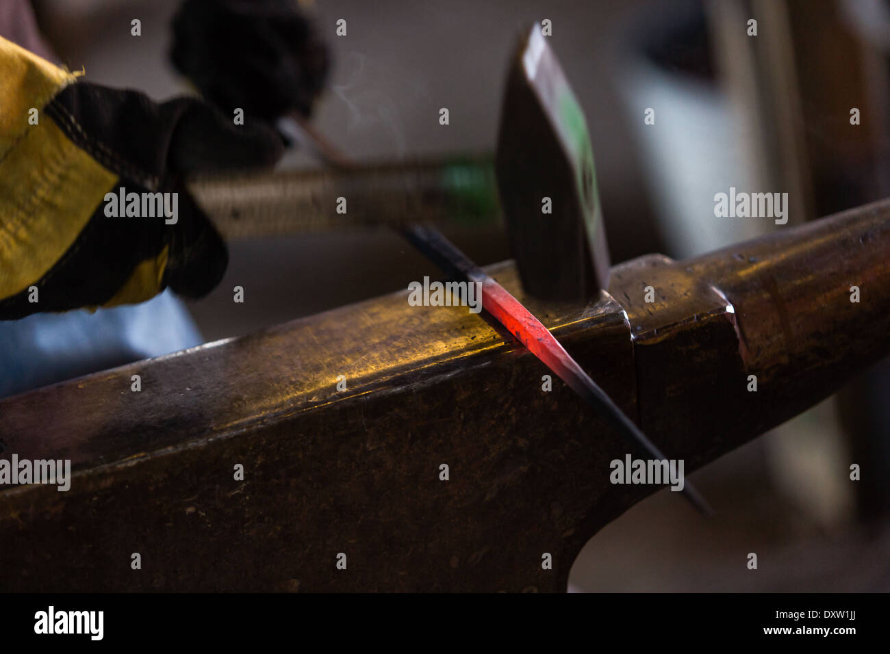 blacksmith bending hot iron on the anvil Stock Photo - Alamy