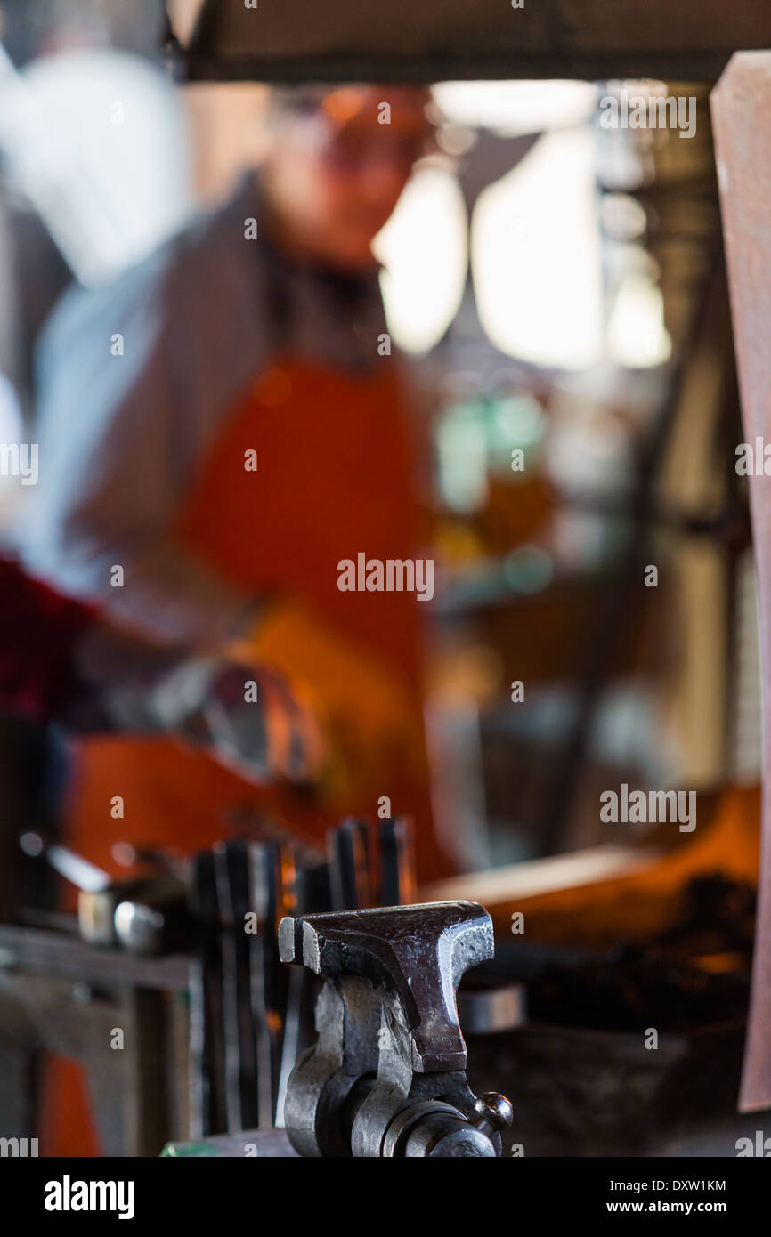 blacksmith bending hot iron on the anvil Stock Photo - Alamy
