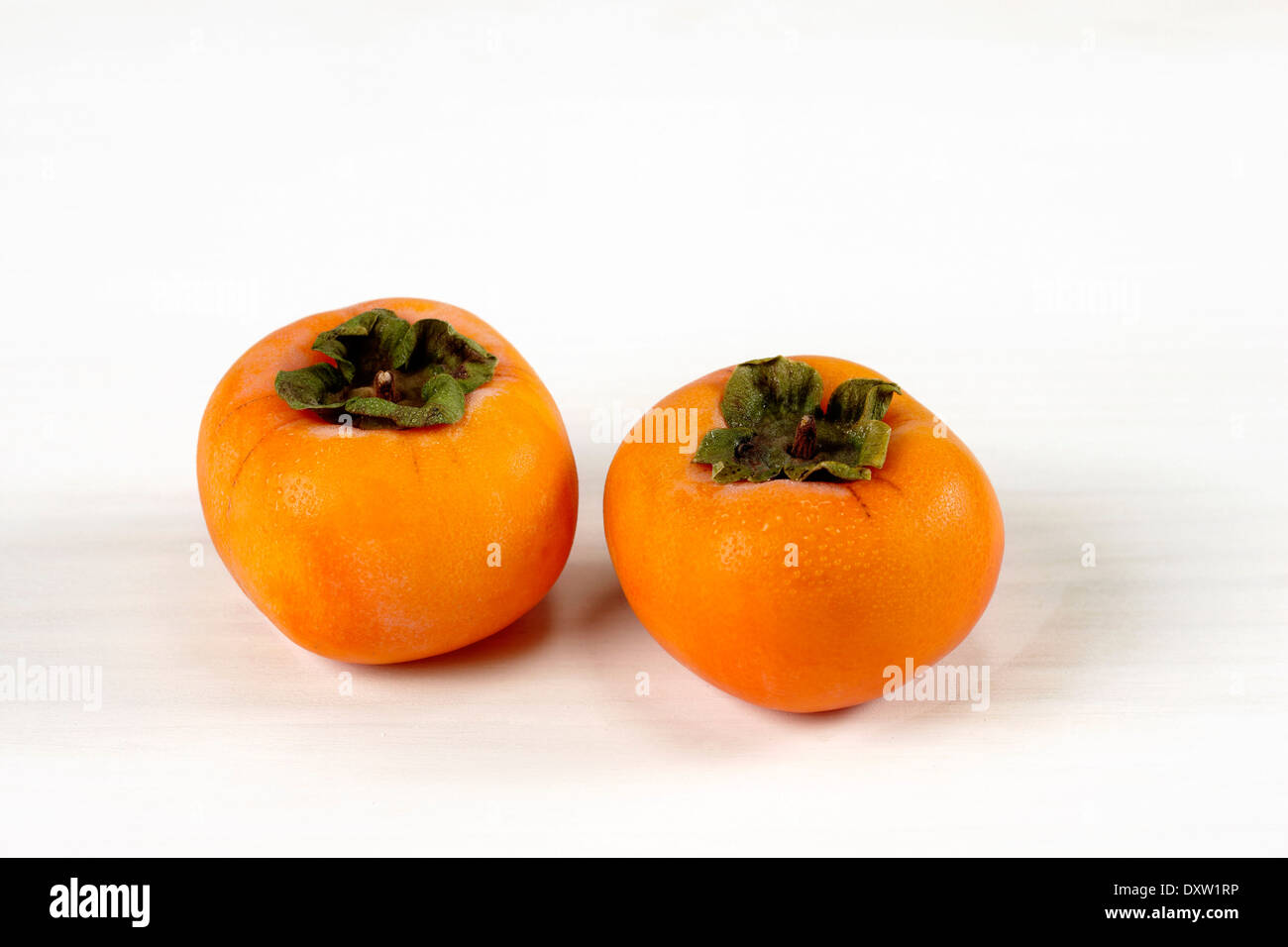 Kakis on a white background Stock Photo - Alamy