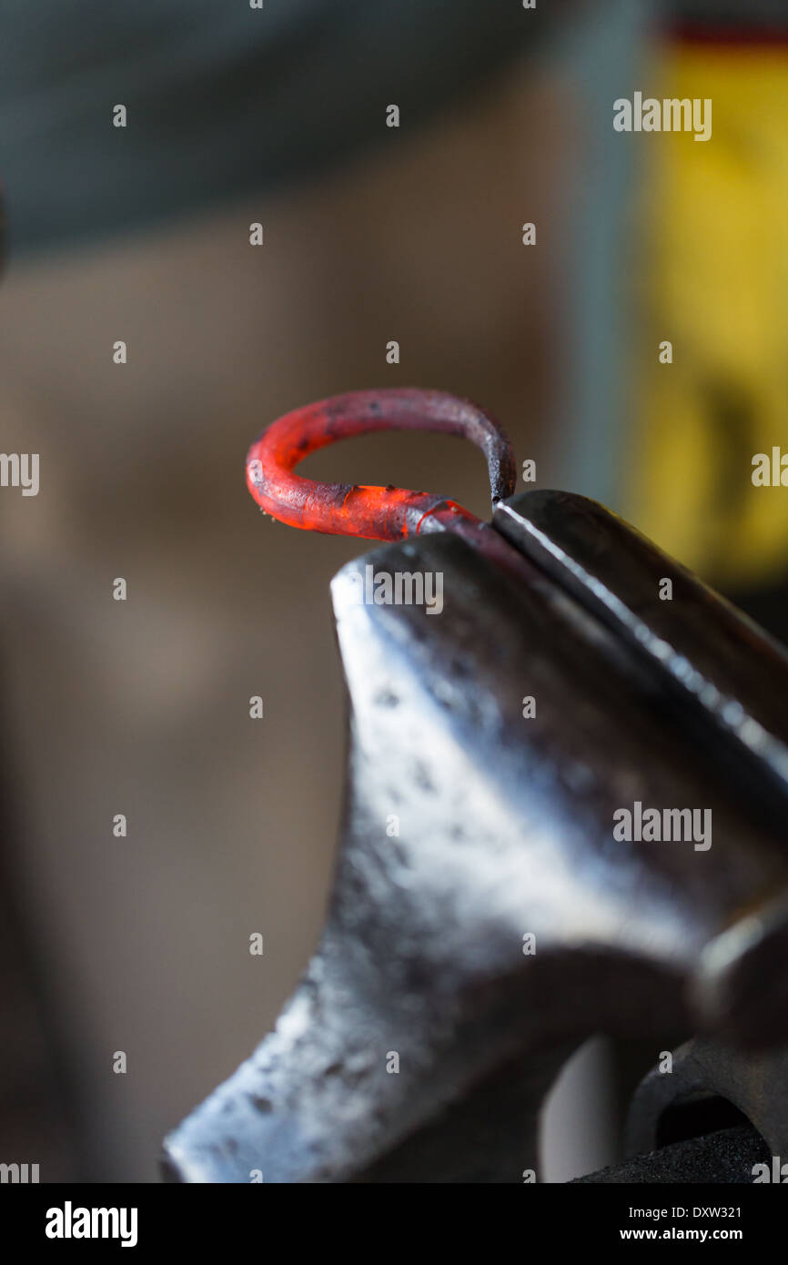 blacksmith bending hot iron on the anvil Stock Photo - Alamy