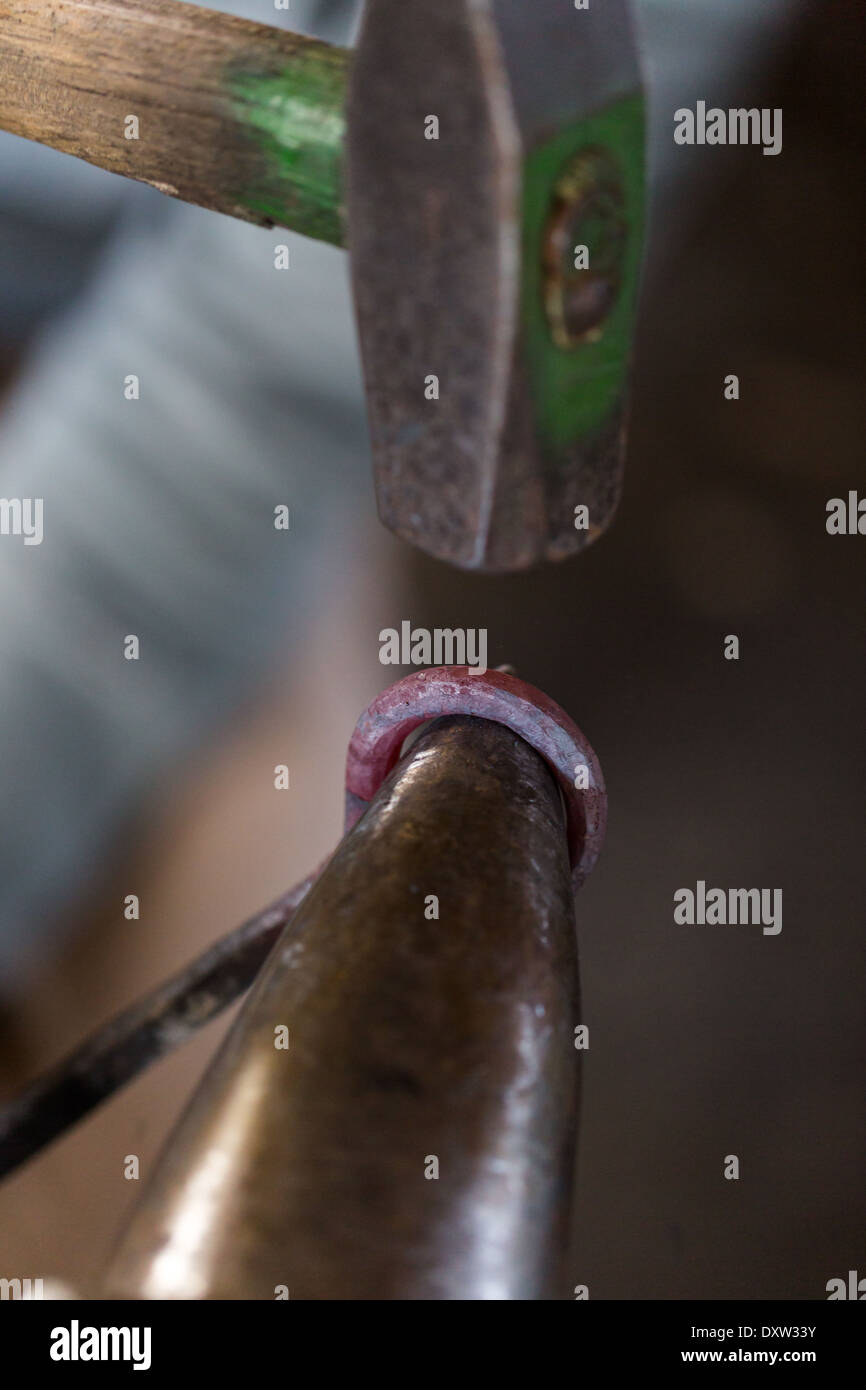 blacksmith bending hot iron on the anvil Stock Photo - Alamy