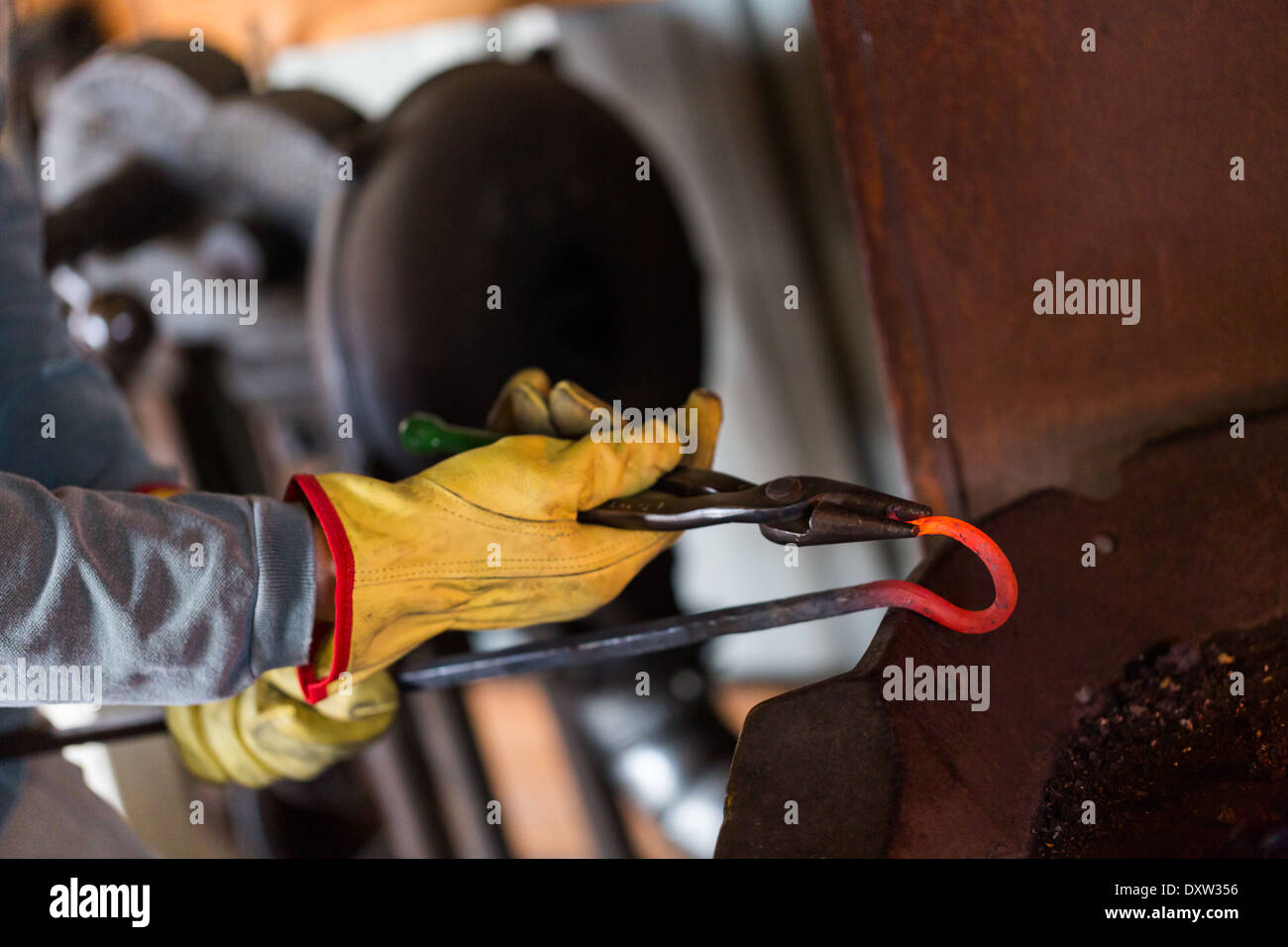 blacksmith bending hot iron on the anvil Stock Photo - Alamy