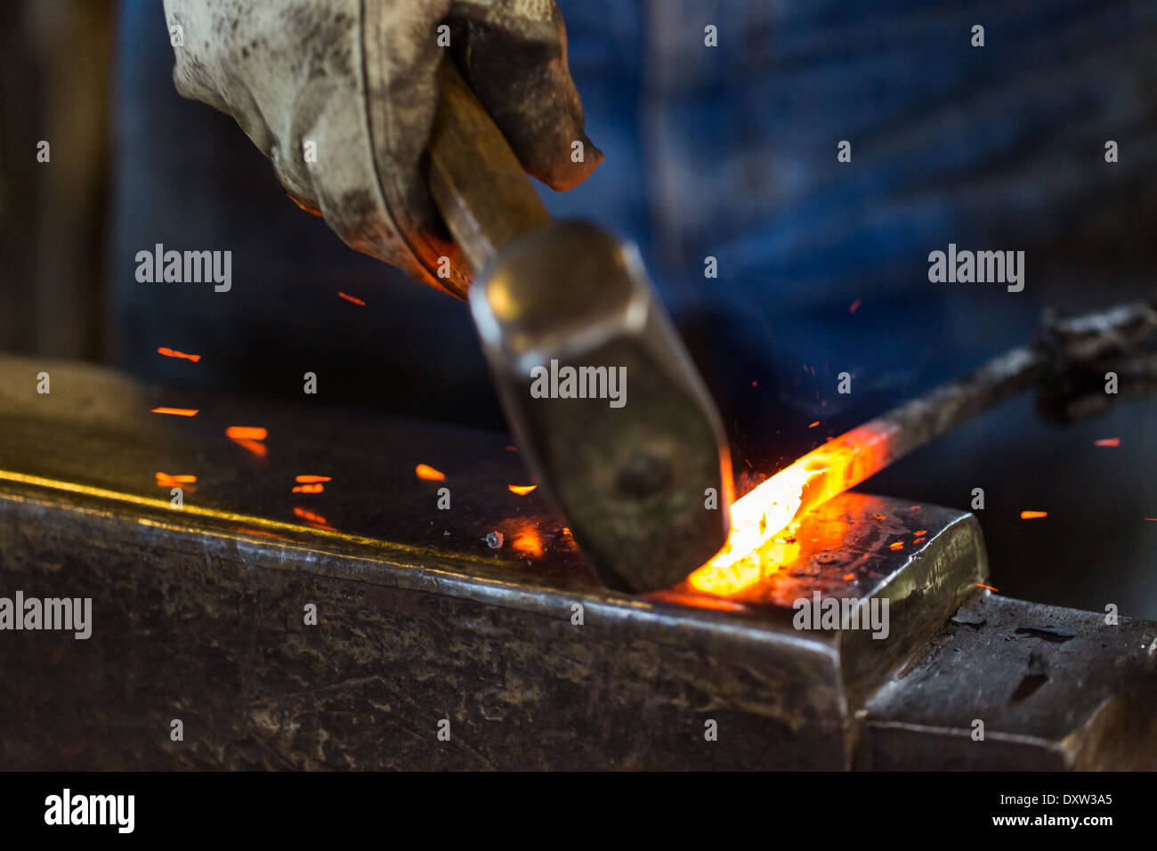 A blacksmith forging hot iron on the anvil Stock Photo - Alamy