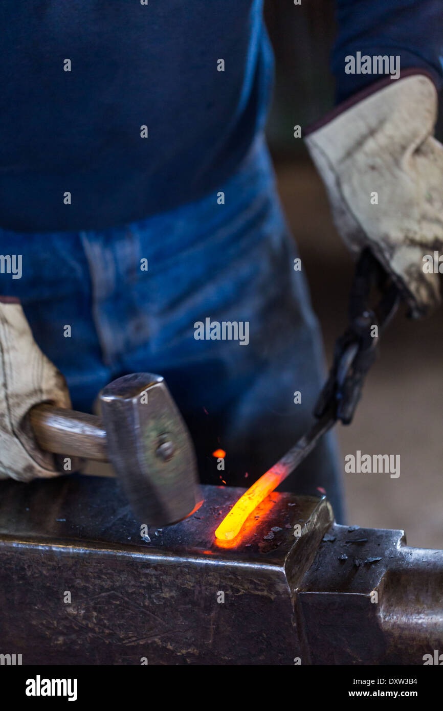 A blacksmith forging hot iron on the anvil Stock Photo - Alamy